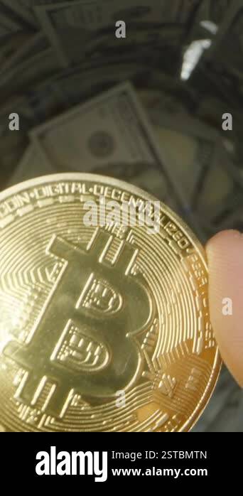Vertical video. Close-Up View of a Gold Bitcoin Coin Mid-Air as It ...