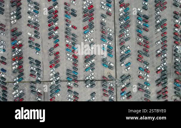 Aerial view of a large parking lot with rows of colorful parked cars ...