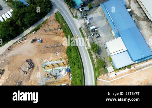 Aerial 4K footage tracking a yellow car along a curved road beside a ...