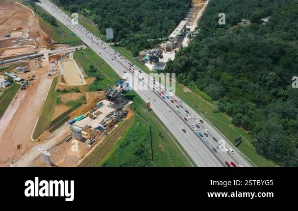 Aerial 4K footage of the ECRL construction near a busy highway. Heavy ...