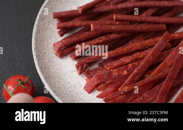 Jerky dried fish sticks with salt and spices on a dark concrete ...