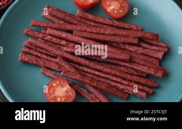 Jerky dried fish sticks with salt and spices on a dark concrete ...