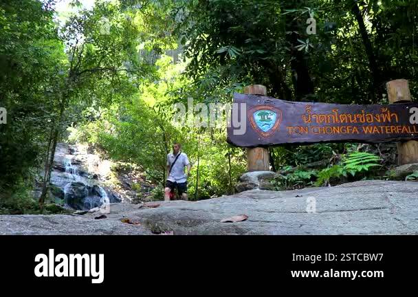 Man male tourist traveler at Ton Chongfa Waterfall entrance welcome and ...
