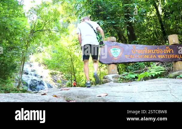 Man male tourist traveler at Ton Chongfa Waterfall entrance welcome and ...
