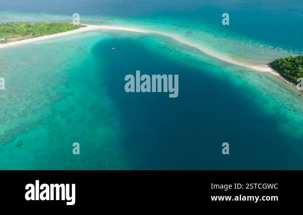 Aerial view of a turquoise lagoon surrounded by tropical greenery and ...