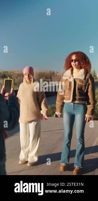 Two friends enjoy dancing together in the sun. Their joyful moments are ...