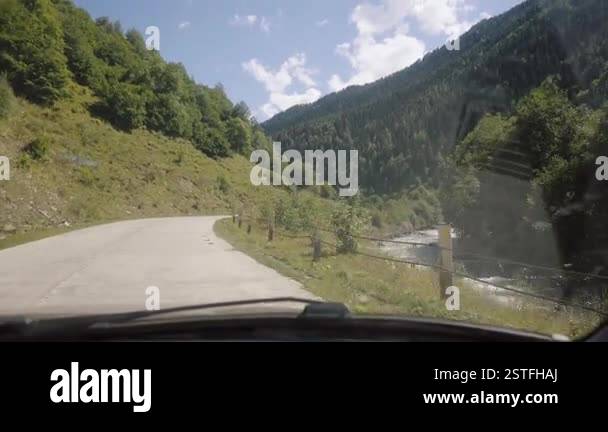 Driving along serpentine mountain road from dashboard perspective ...