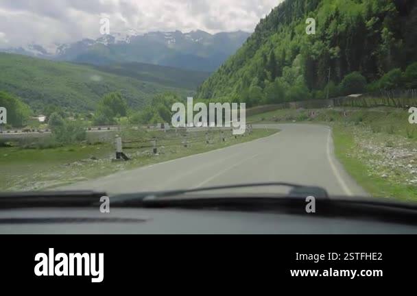 View from car window, Drive along winding mountain road surrounded by ...