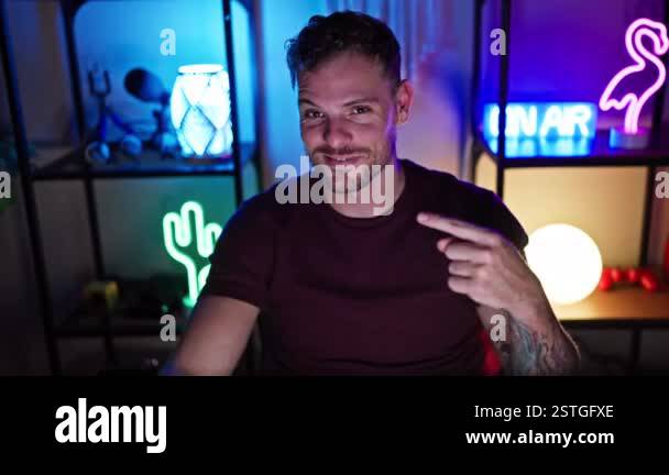 Excited young man, an optimistic gamer with beard, proudly pointing at ...