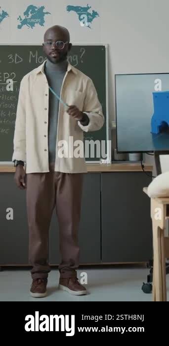 Vertical shot of African American male teacher standing in front of ...