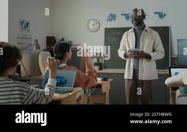 African American male teacher asking questions during 3D modelling ...
