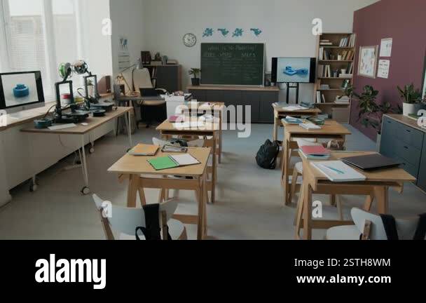 Interior of bright classroom with student desks and learning materials ...