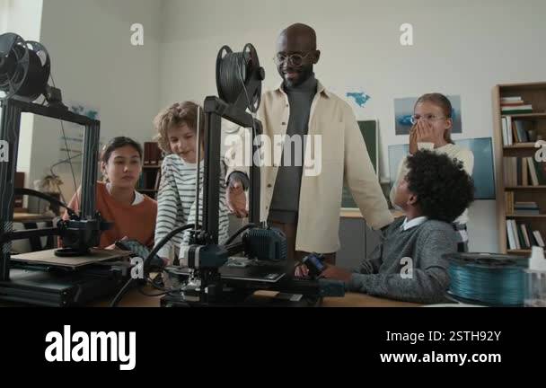 African American male teacher showing group of children from elementary ...
