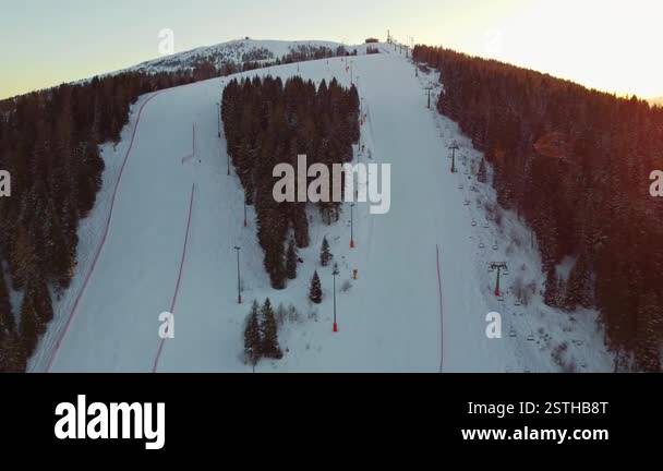View from above panorama of snowy mountain with ski slopes at sunset ...