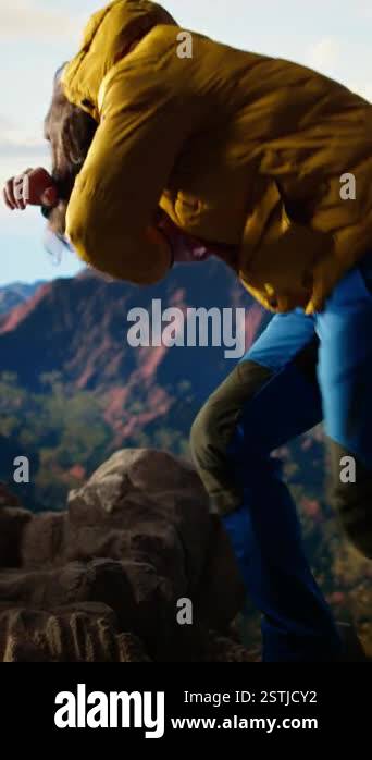 Vertical Video Clumsy traveler loses balance on a steep mountain peak ...