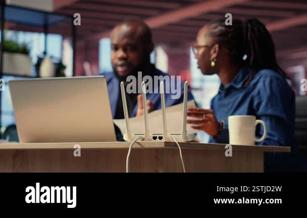 Black irritated man and woman rebooting their wireless router and ...