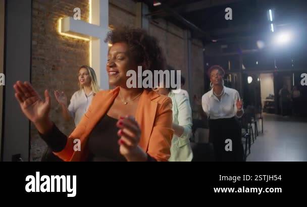 Diverse group of people clapping and smiling during worship in a church ...