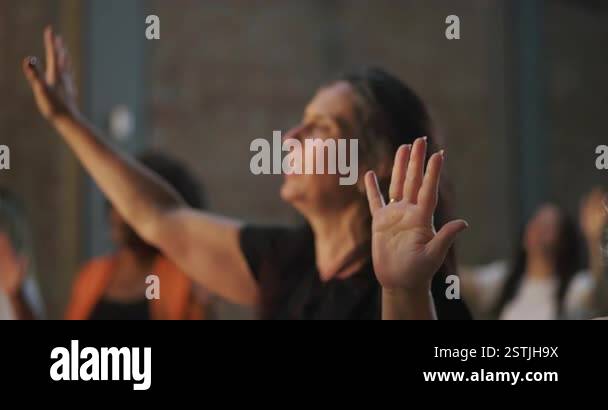 Woman with hand raised in prayer, deep spiritual connection, worship ...