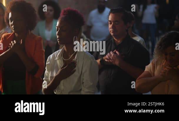 Congregation worshipping with hands on heart during evangelical church ...