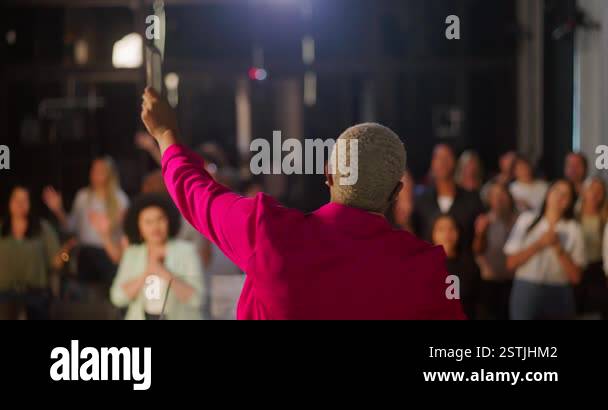 Speaker leading a congregation, back view, holding a Bible with hand ...