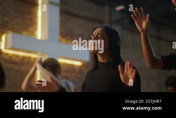 Focused woman with raised hands in prayer, deep spiritual connection ...