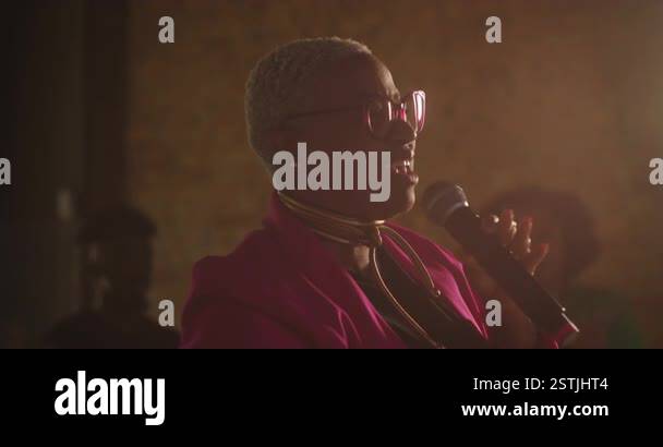 African American preacher speaking into microphone during worship ...