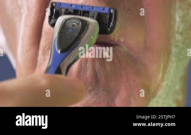 Closer look of the razor blade shaving the small mustache on top of the ...