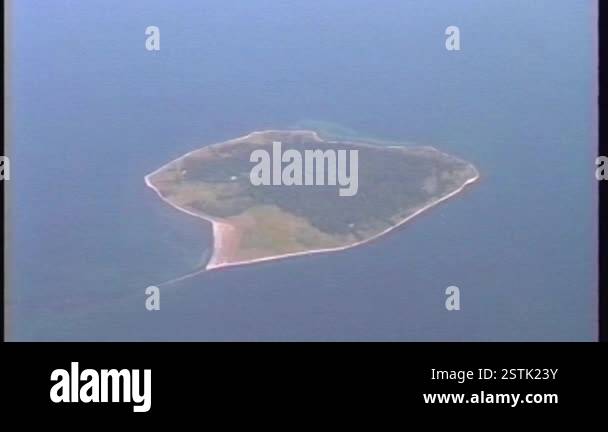 A VHS video captures an aerial view of a small, remote, diamond-shaped ...