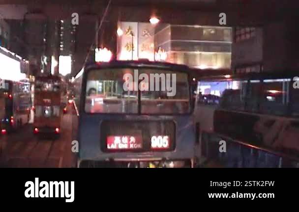 A busy nighttime street scene in Hong Kong unfolds from the rear of a ...
