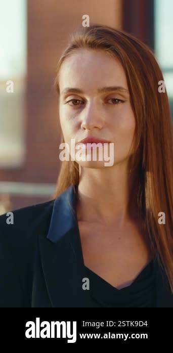 A confident woman with long brown hair appears in a stylish black ...