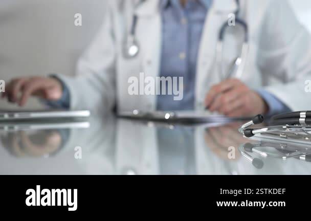 Stethoscope and medication history records form are on a glass table ...