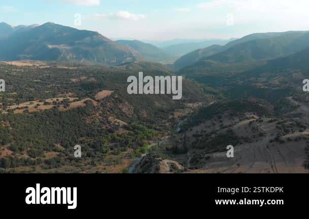 Aerial view of serpentine narrow road snaking between mountains in West ...