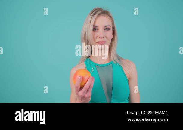 A fitness enthusiast confidently poses with a bright orange, promoting ...