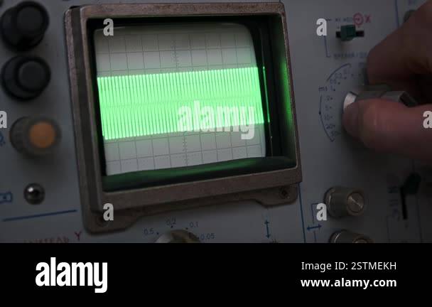 A vintage oscilloscope showing frequency changes via adjustments of a ...