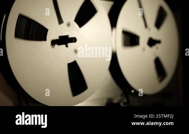 Close-up showing the spools turning of a retro reel-to-reel tape ...