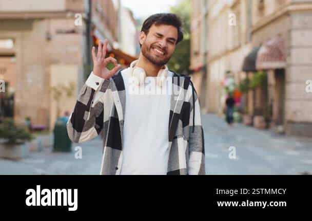 Okay. Happy cheerful young Indian man looking approvingly at camera ...