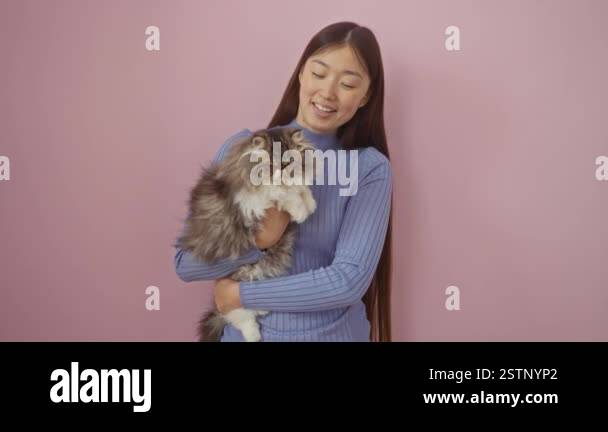 Young chinese woman and cat standing together, smiling happily with ...