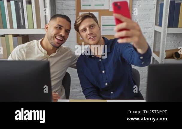 Handsome men taking selfie with smartphone while working in an office ...