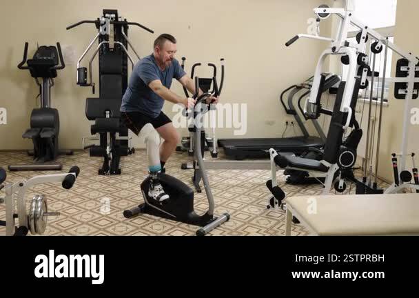 Fitness center, Strength press, Rehabilitation workout. Fitness buff with prosthetic leg works ...