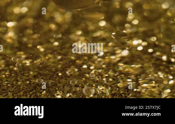 Serum bubbles. Paint water flow. Defocused golden yellow color ...
