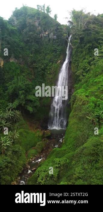 Aerial panoramic portrait of a beautiful waterfall nestled among lush ...