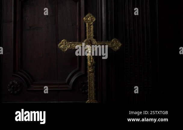 Large golden crucifix inside a dark sacristy. Sacred objects for ...