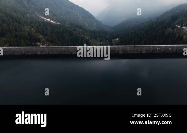 Huge dam in a vast valley in the mountains. Epic aerial shot of a ...
