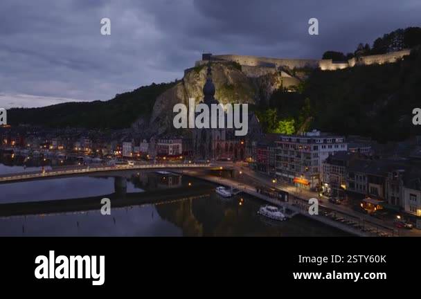 Cars drive over a bridge in Dinant, Belgium. The Citadel is illuminated ...