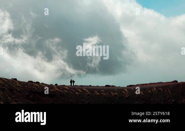 Small group of hikers walk on top of a mountain. Wonderful shot of huge ...
