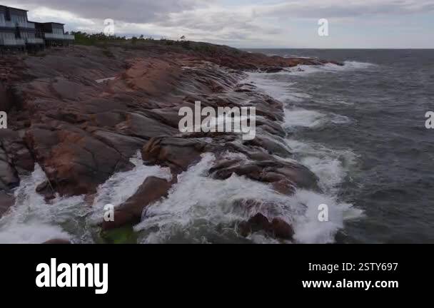 Ocean waves crashing against a rugged coastline in Aland, Finland ...