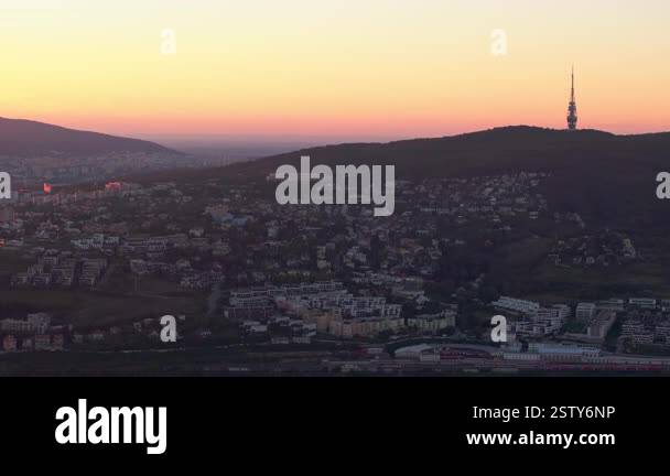 Warm sunset colors paint the sky above Bratislava, Slovakia. The iconic ...