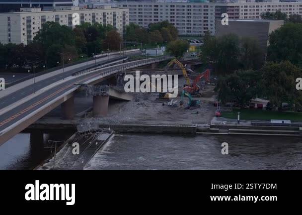 Aerial footage captures excavators dismantling a bridge over a river in ...