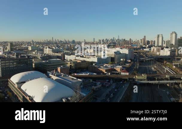Aerial view capturing sunny New York City morning in Queens borough, revealing urban skyline and ...