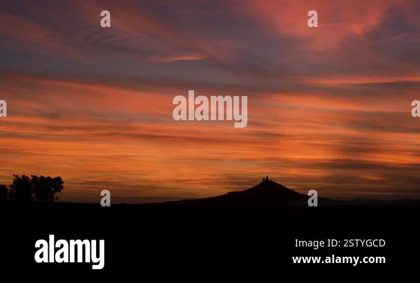 Timelapse of magnificent bright red sunset sky above magical dark ...